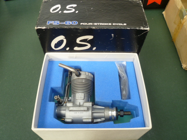 An OS FS-60 four stroke engine with silencer (brand new) in original box.