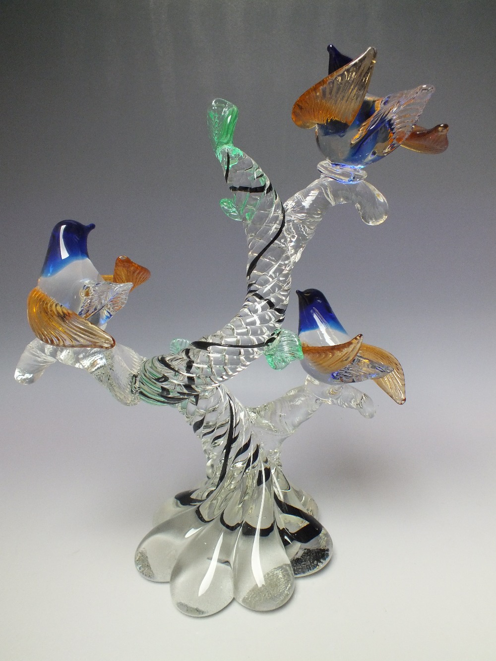A LARGE ART GLASS BIRD SCULPTURE DEPICTING THREE BIRDS SEATED IN A TREE ...