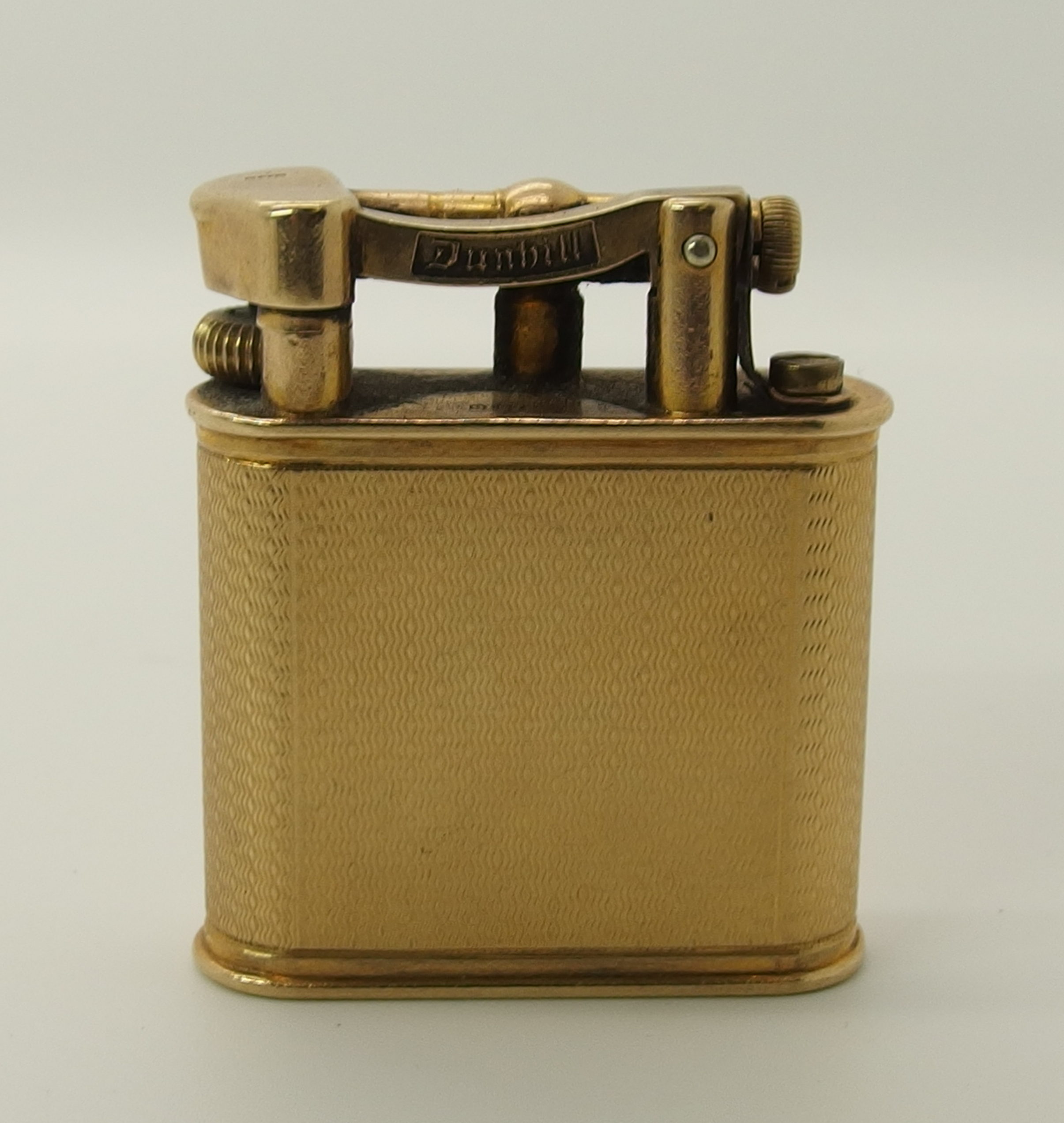 A 9ct gold vintage Dunhill lighter with engine turned decoration to the ...