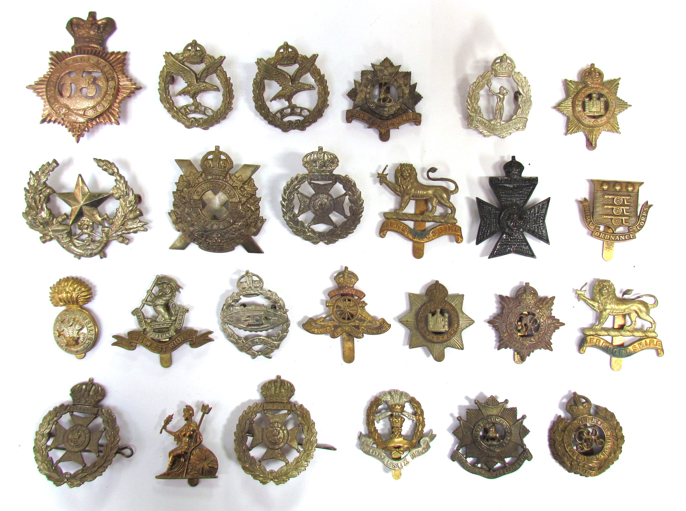 A collection of cap badges, approximately 40 regiments
