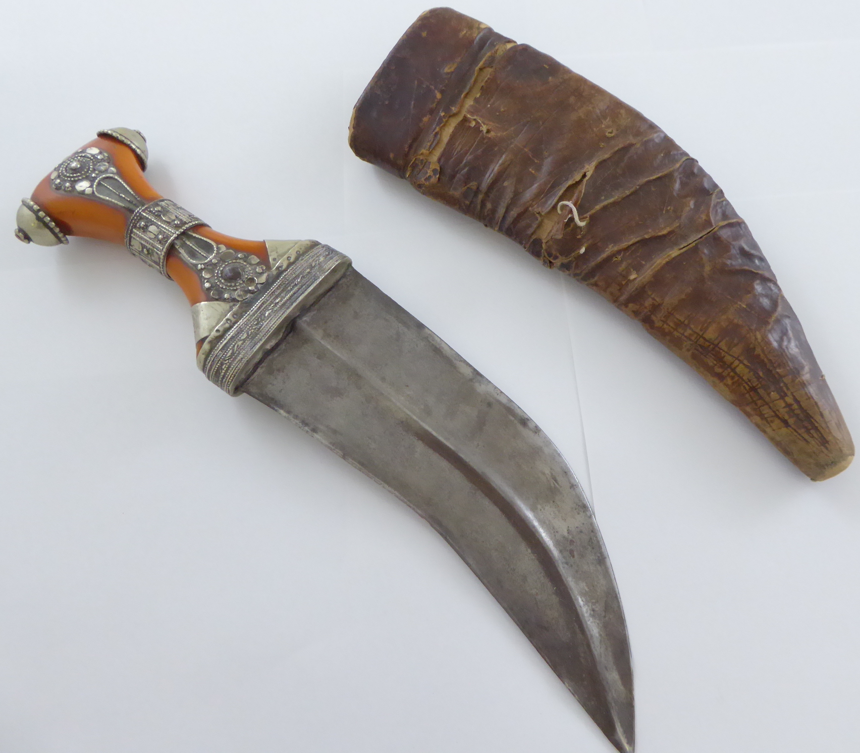 A Middle Eastern dagger with silver mounts, leather scabbard with ...