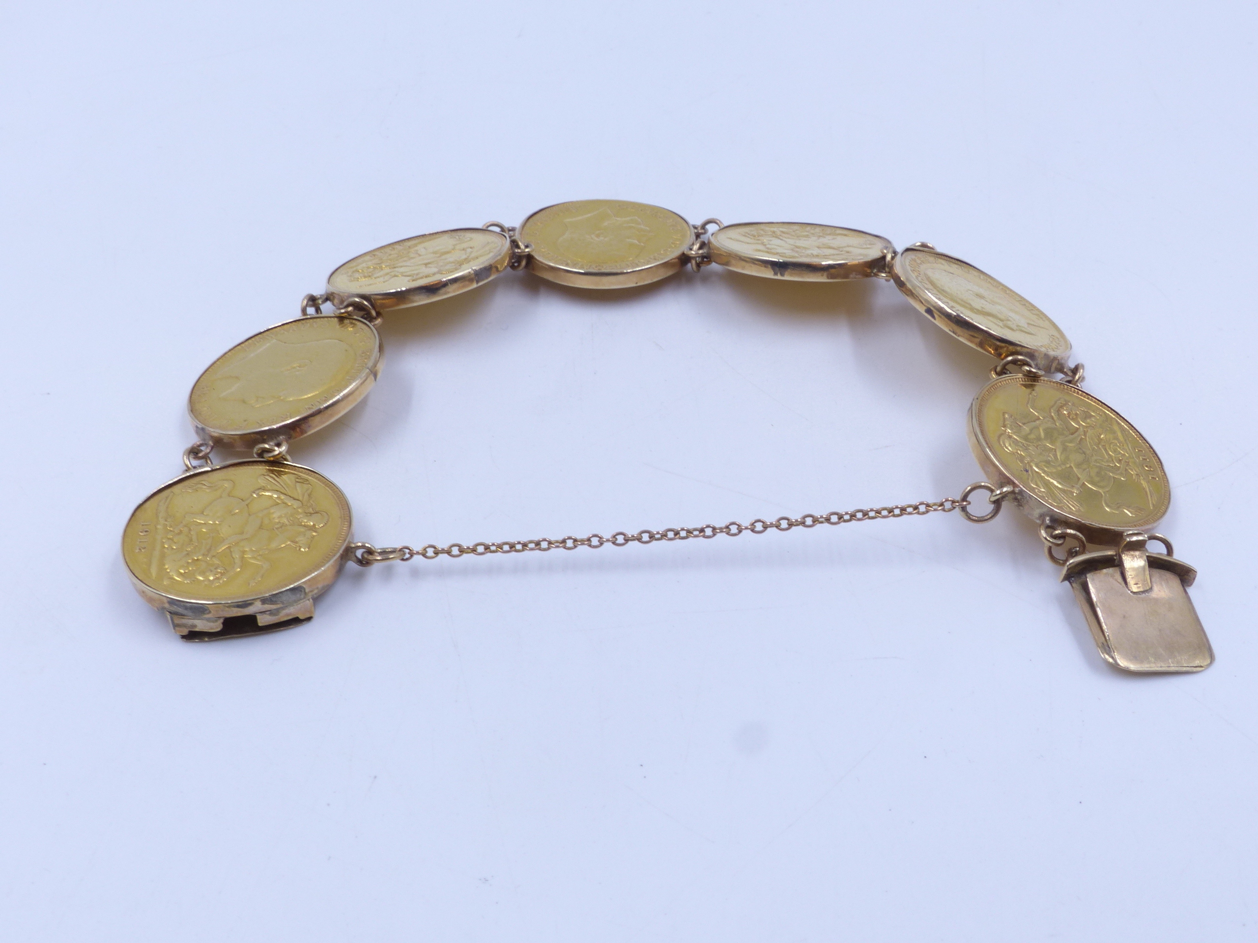A GOLD SOVEREIGN BRACELET MADE UP OF SEVEN INDIVIDUALLY SET FULL ...