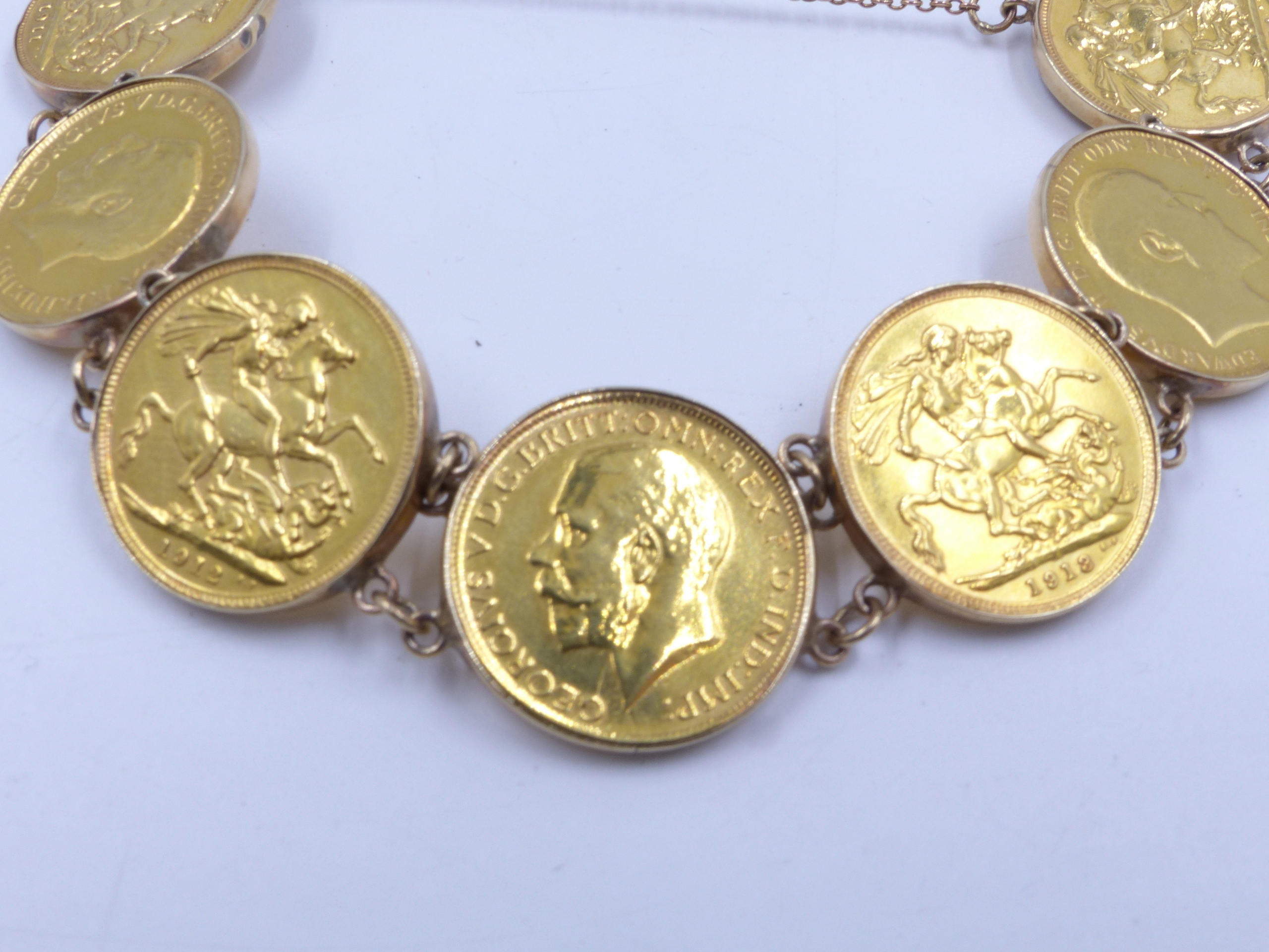 A GOLD SOVEREIGN BRACELET MADE UP OF SEVEN INDIVIDUALLY SET FULL ...