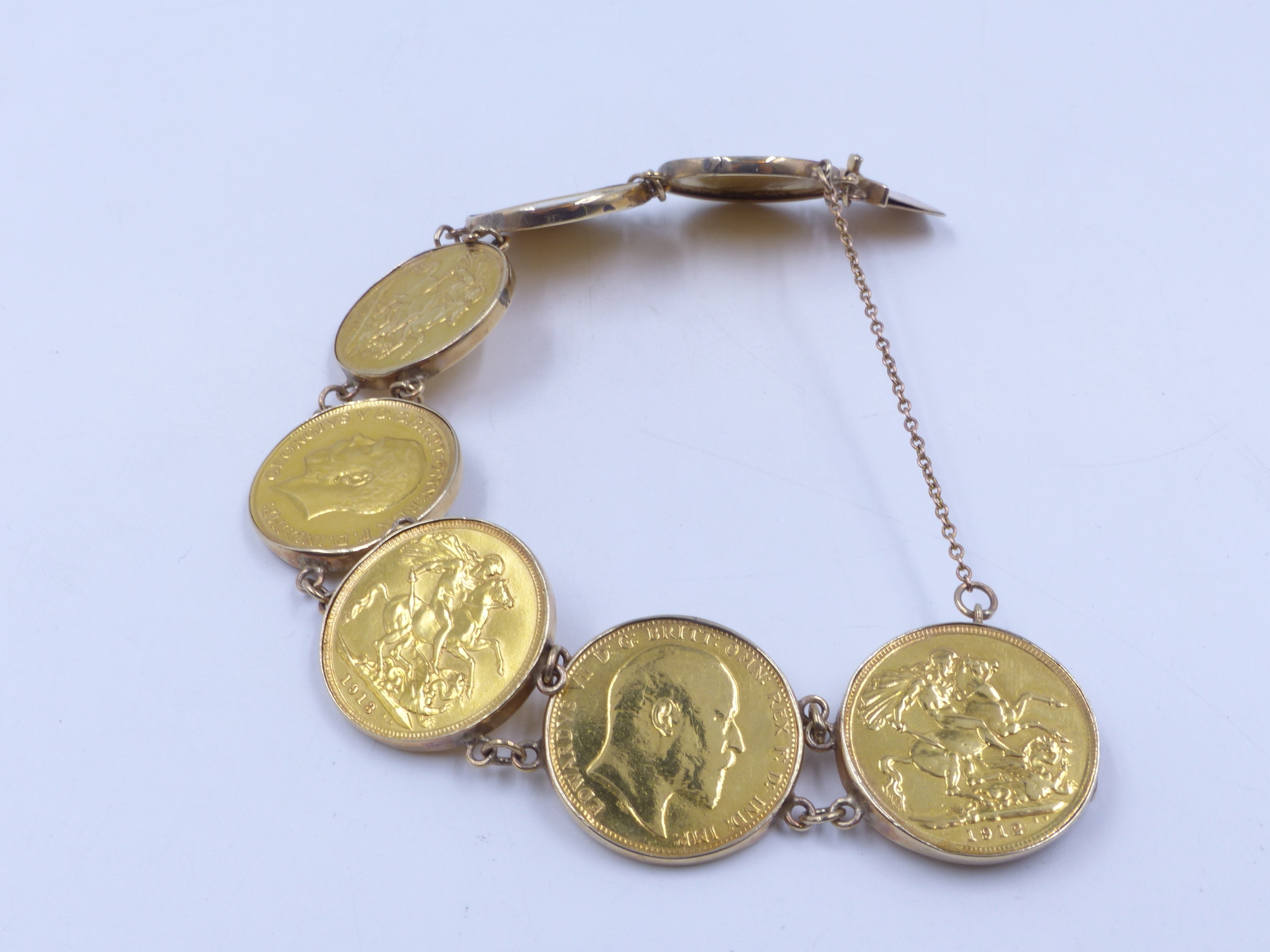 A GOLD SOVEREIGN BRACELET MADE UP OF SEVEN INDIVIDUALLY SET FULL ...