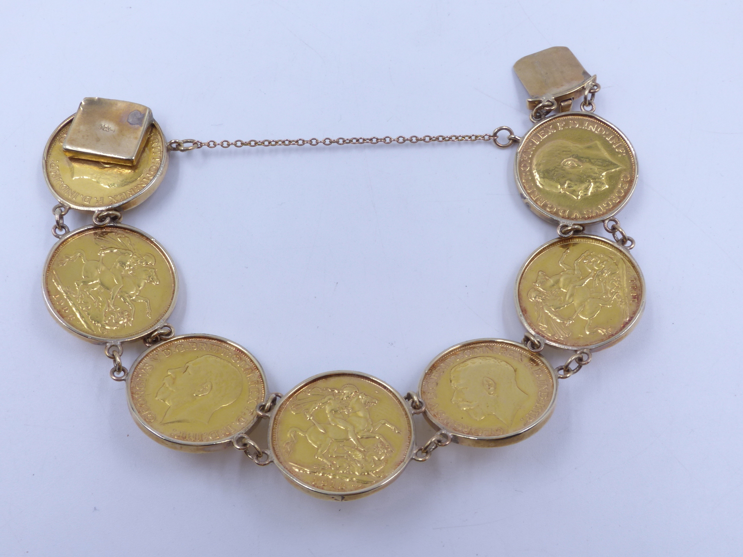 A GOLD SOVEREIGN BRACELET MADE UP OF SEVEN INDIVIDUALLY SET FULL ...