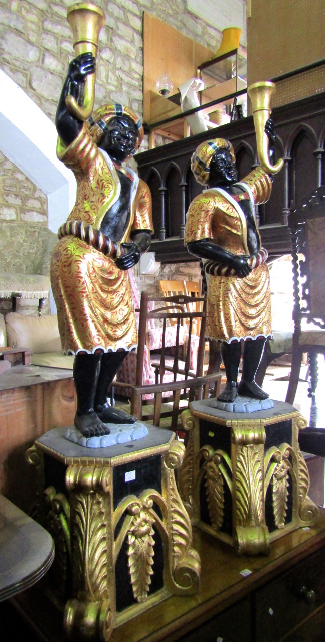 A pair of carved wooden Blackamore figures in standing pose with ...