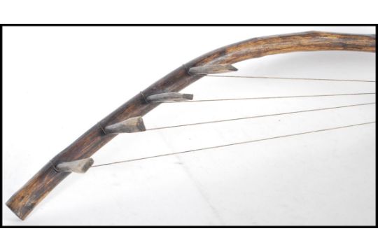 A 20th Century Kenyan tribal Orutu strung musical instrument having a ...