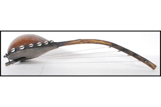 A 20th Century Kenyan tribal Orutu strung musical instrument having a ...