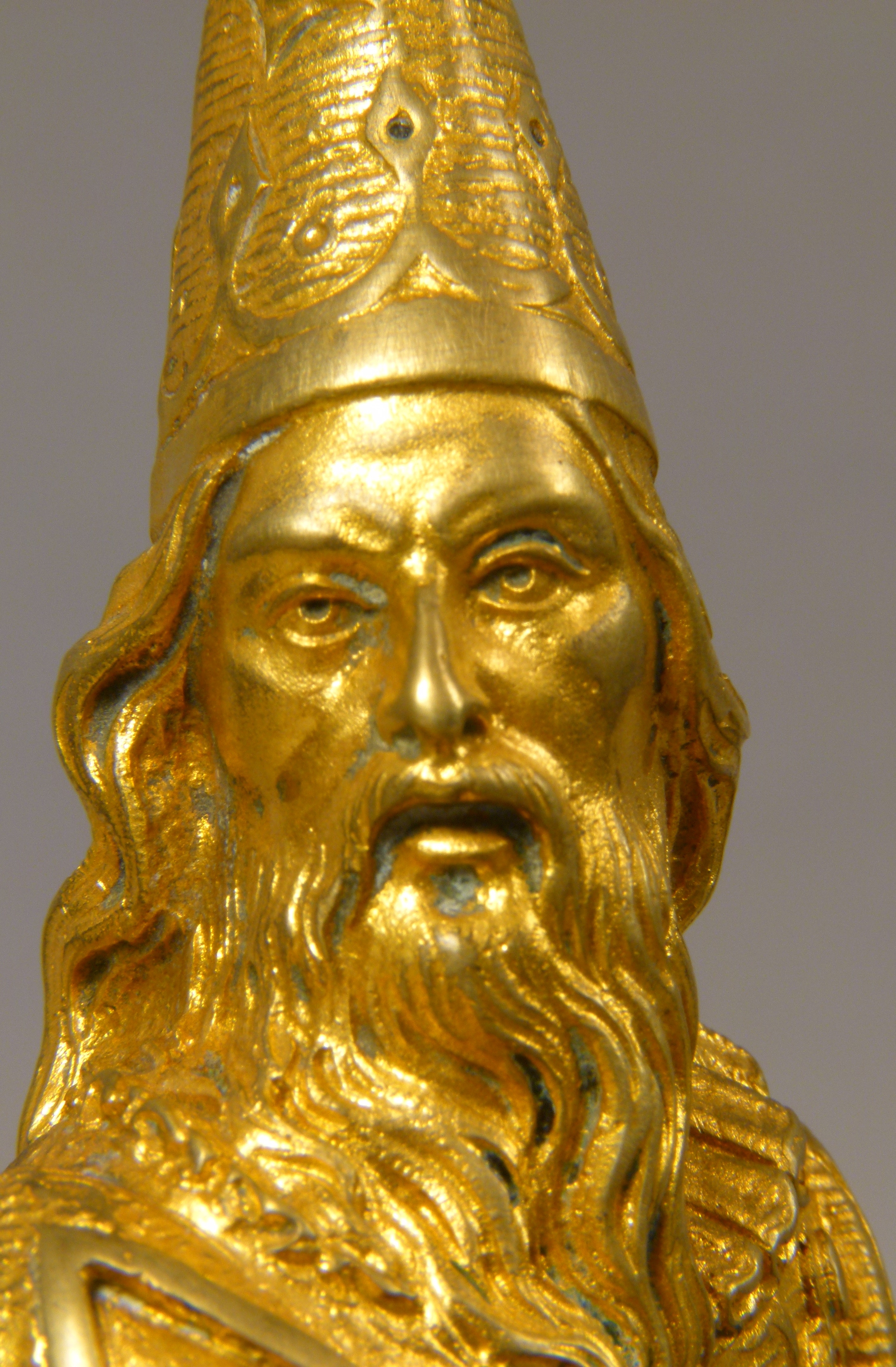 A LATE 19TH CENTURY GILT BRONZE FIGURE OF A BEARDED WIZARD, wearing ...
