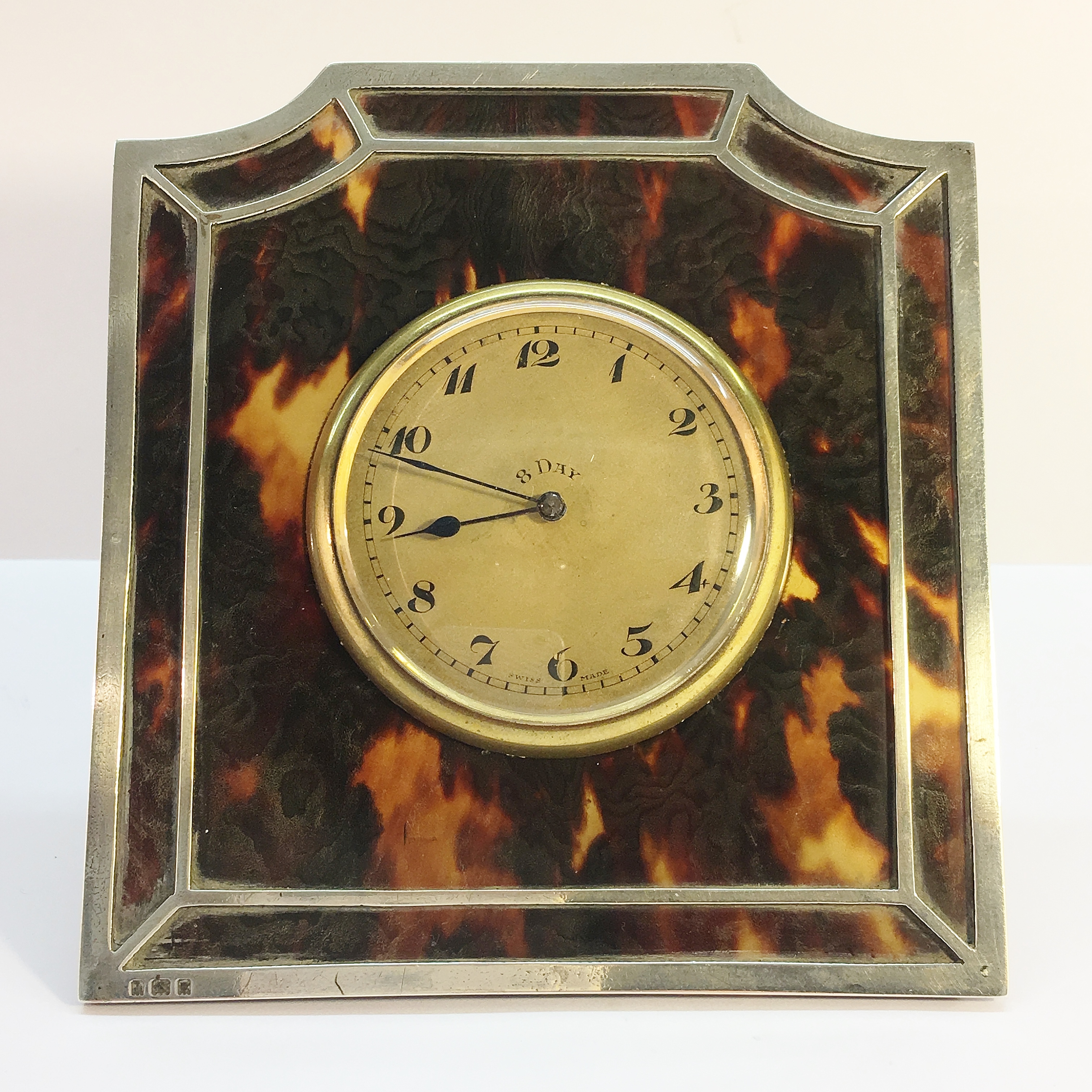 A silver and tortoise shell 8 day clock.