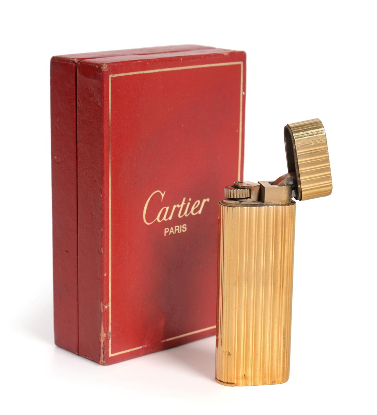 A Gold and Gold-Plate Mounted Cigarette-Lighter, Retailed by Cartier ...