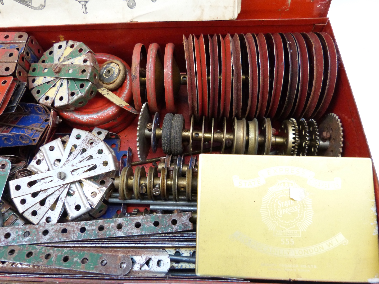A collection of various Meccano parts including gears and wheels in ...