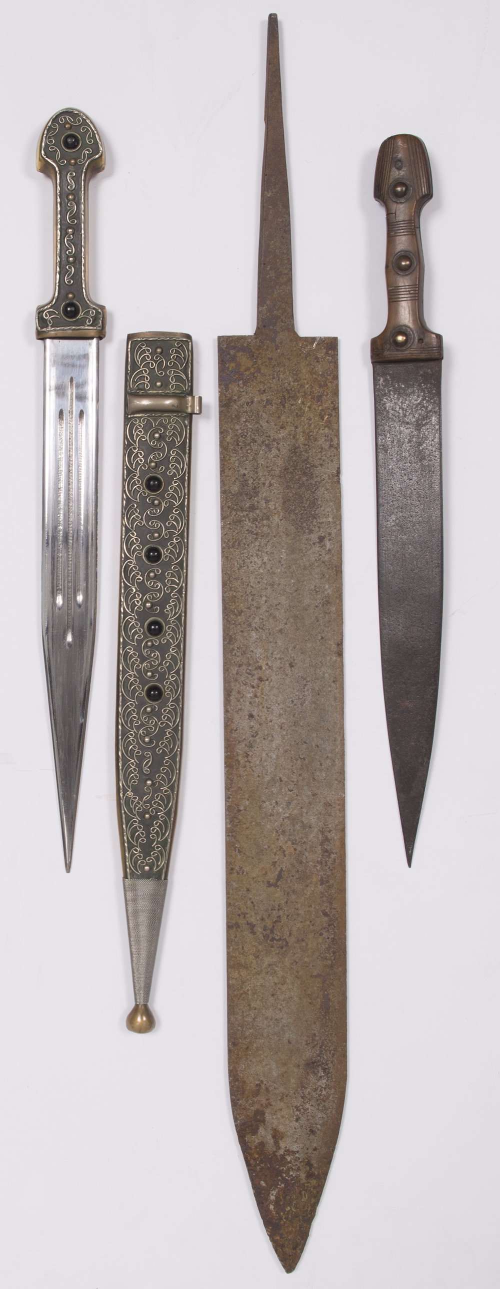 A collection of three Middle Eastern daggers one with sheath inset with ...