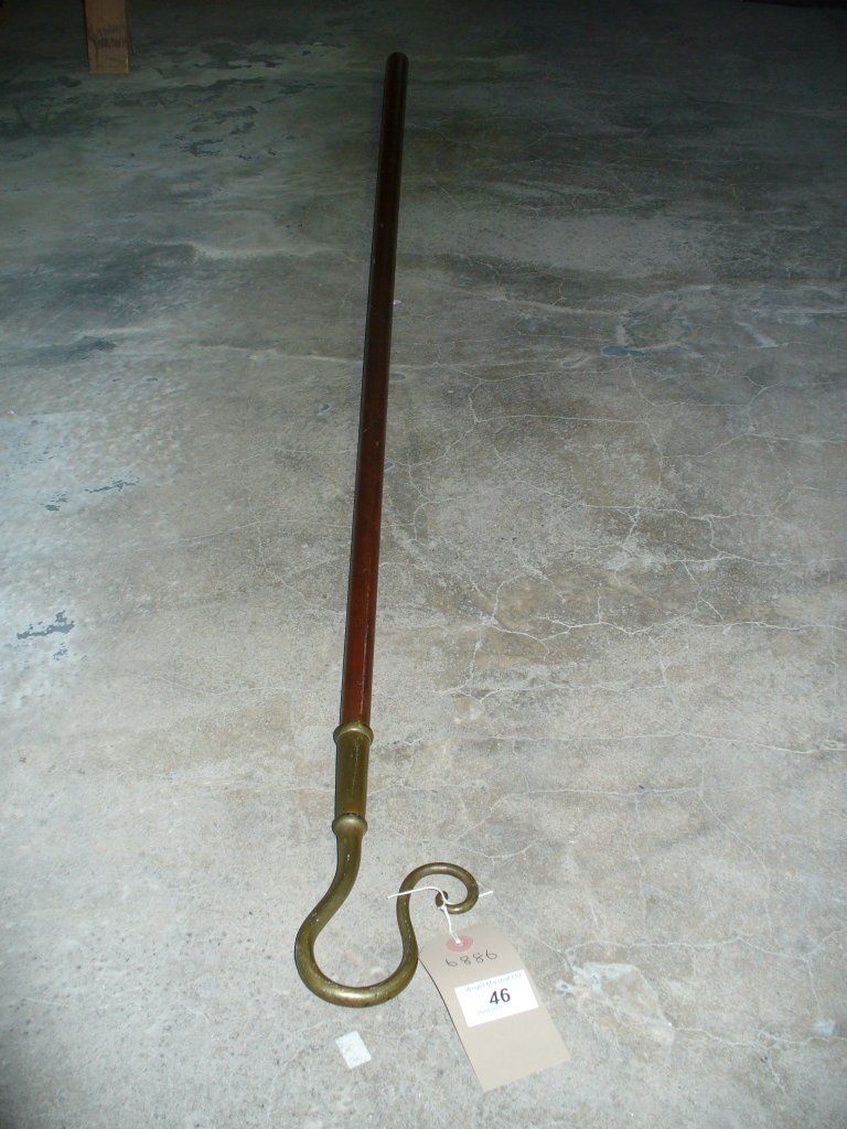 A Vintage shepherds crook with a scrolling brass hook mounted on a ...