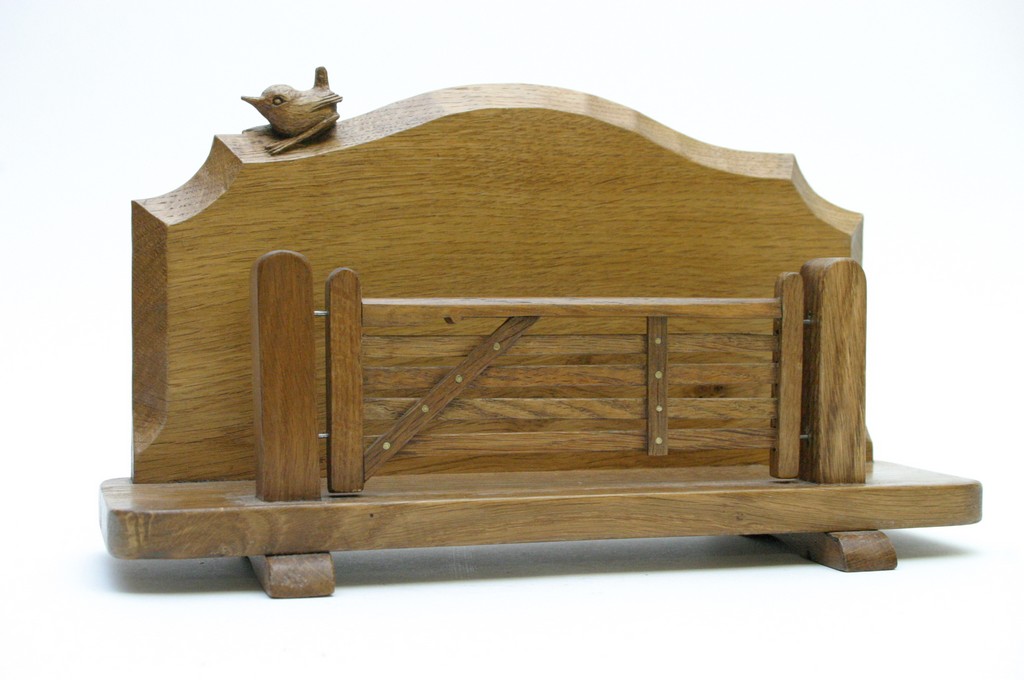A carved oak Bob Hunter Wren Man letter rack with five bar gate design