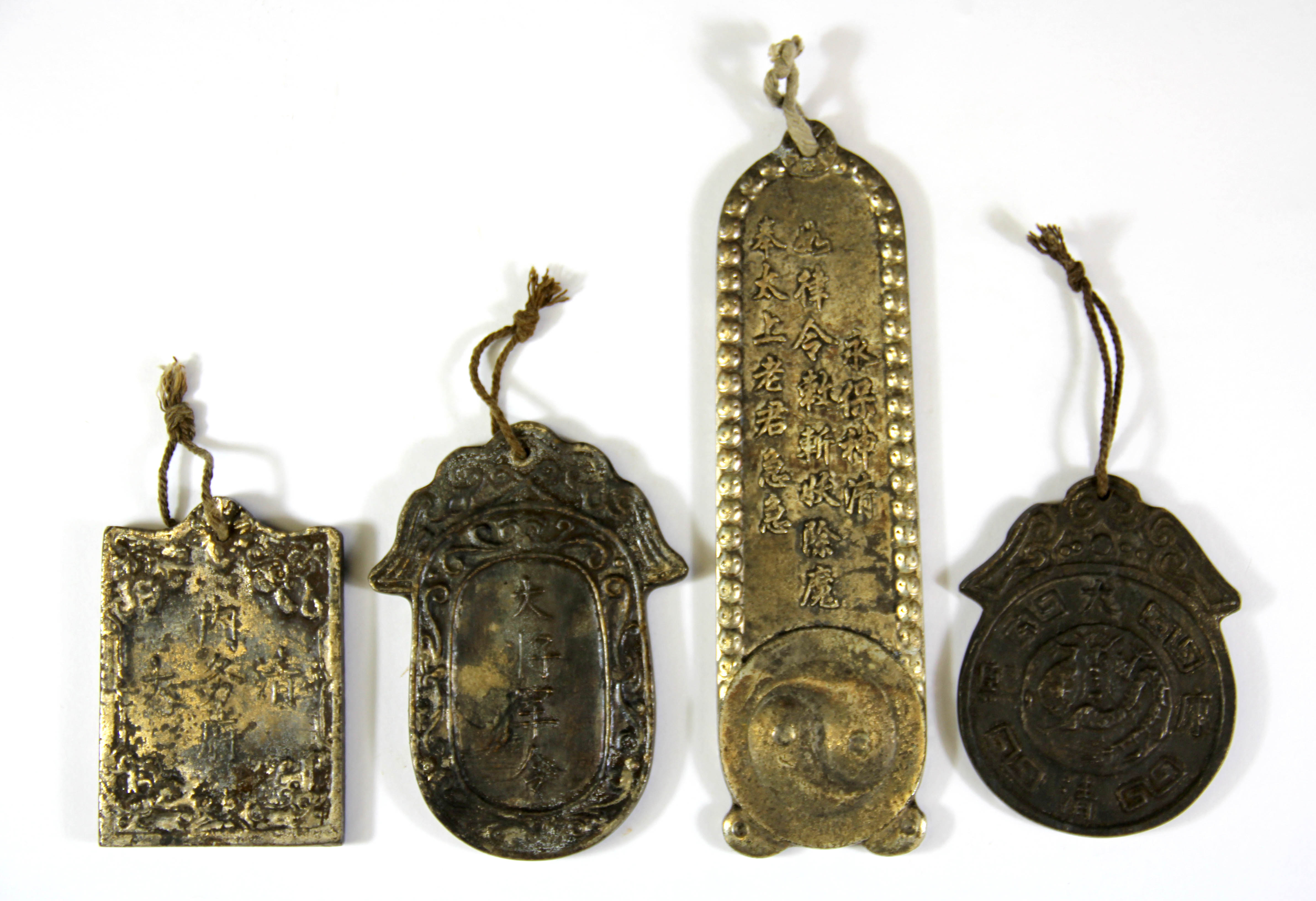 Four Chinese metal protective amulets.