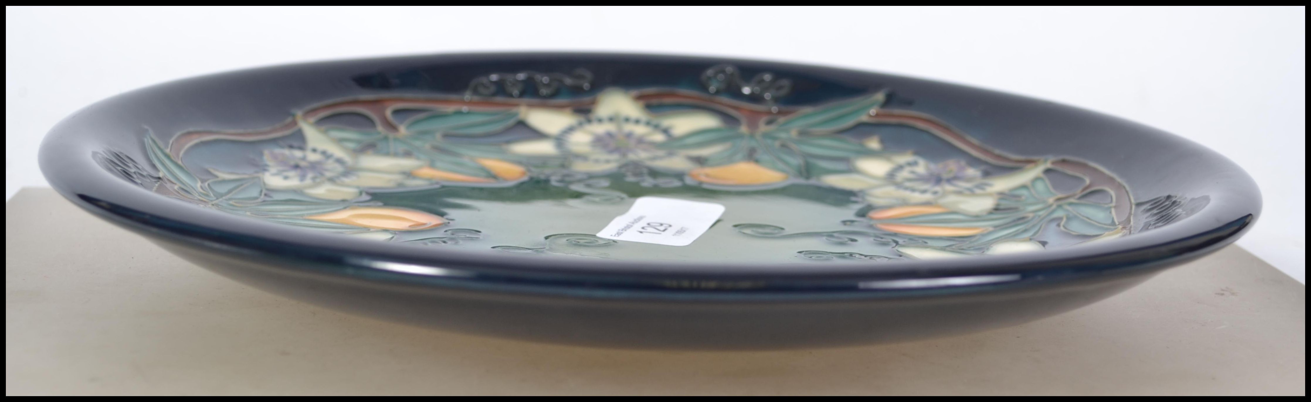 A William Moorcroft plate being marked to the back for Moorcroft Made ...