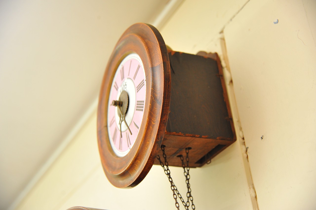 A postman's alarm clock with pink and white enamel face.