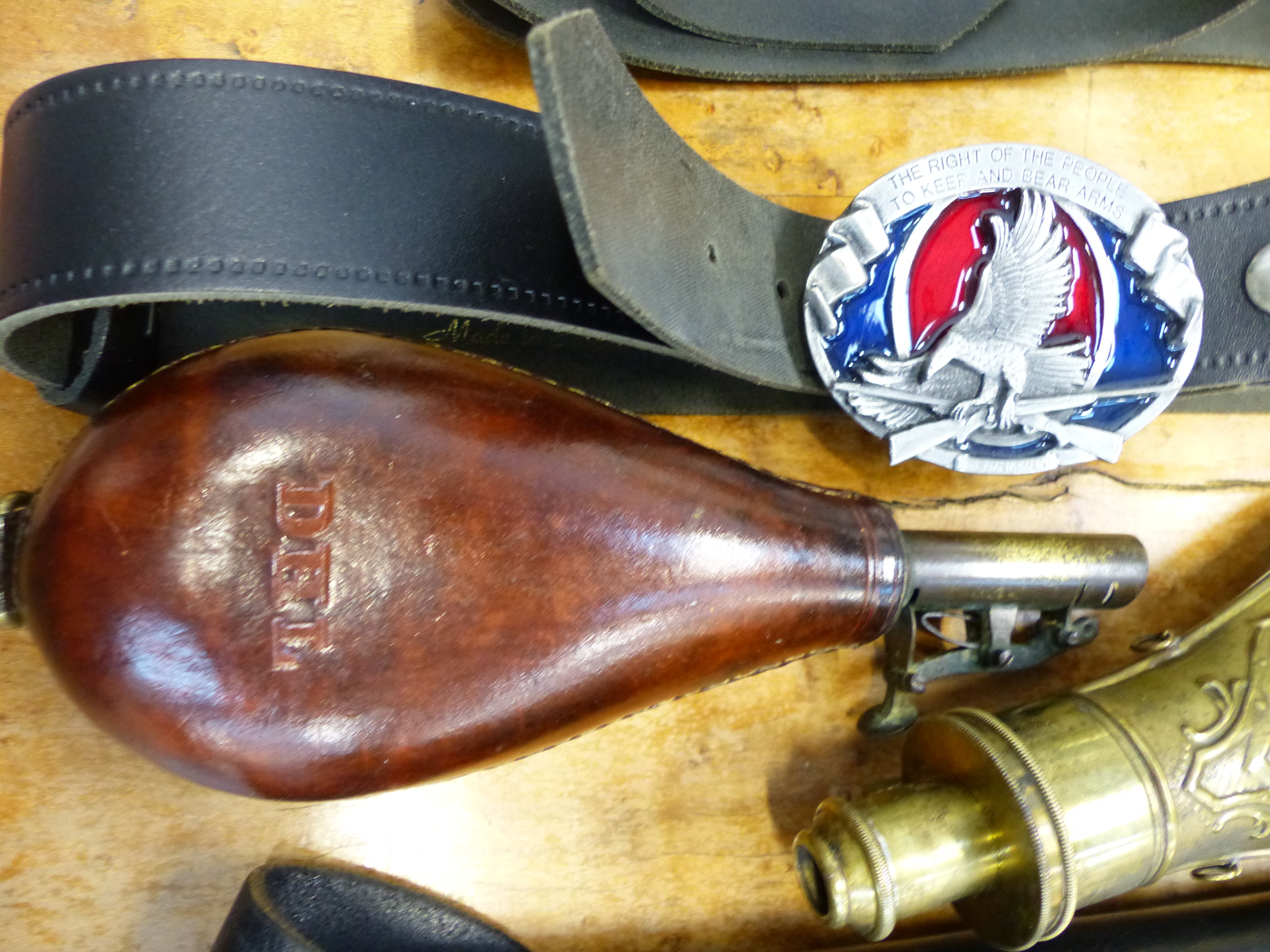 AN ANTIQUE LEATHER SHOT FLASK, A BRASS POWDER FLASK, TWO WESTERN STYLE ...