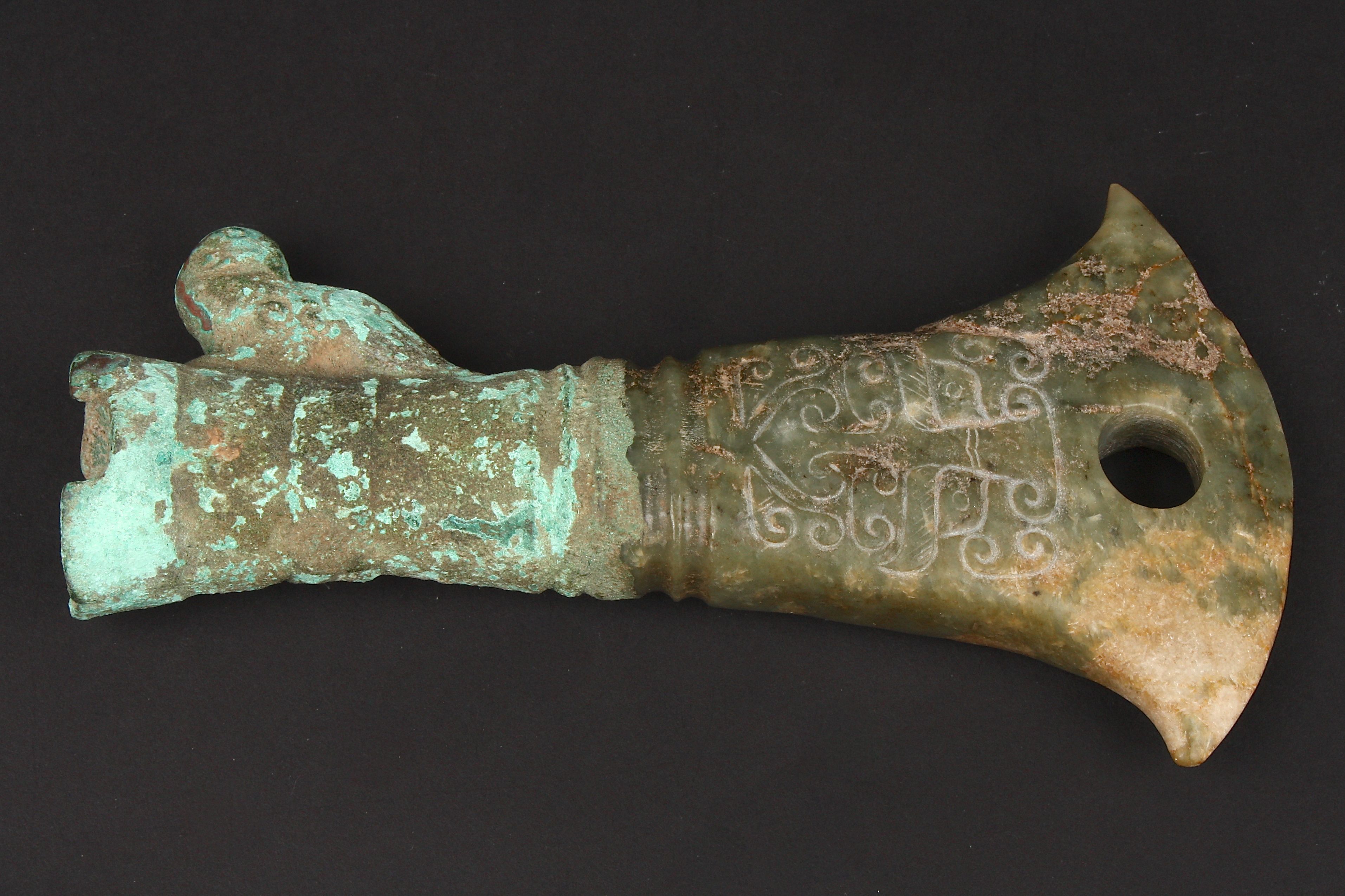 A carved jade axe head in archaic style the jade carved in low relief ...