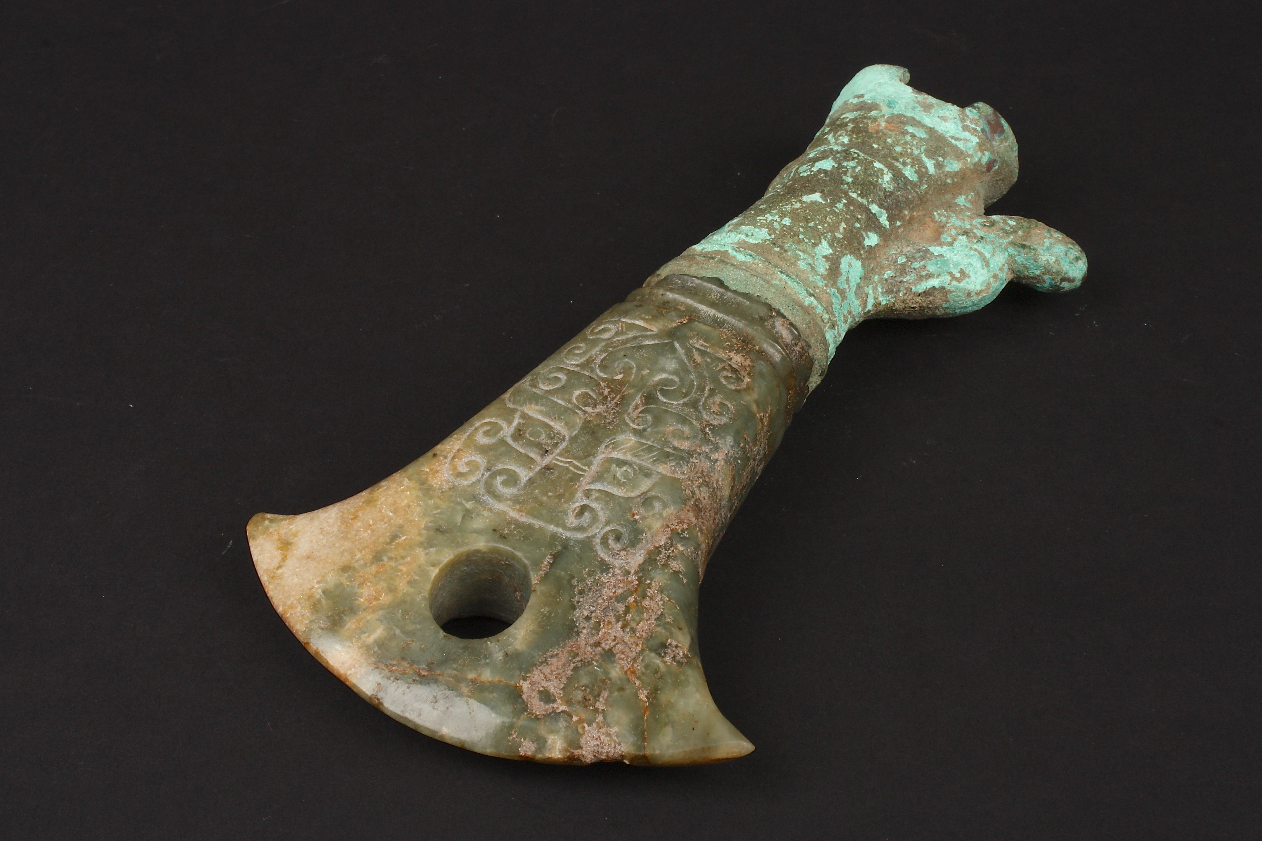 A carved jade axe head in archaic style the jade carved in low relief ...