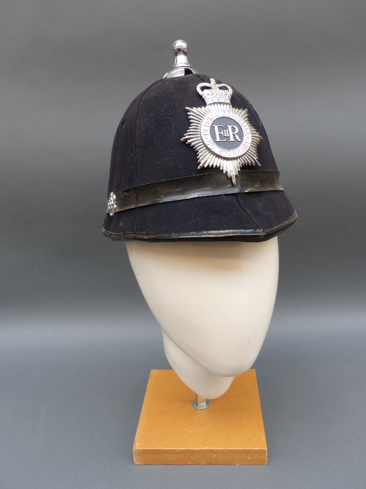 Three vintage police helmets including Devon and Cornwall