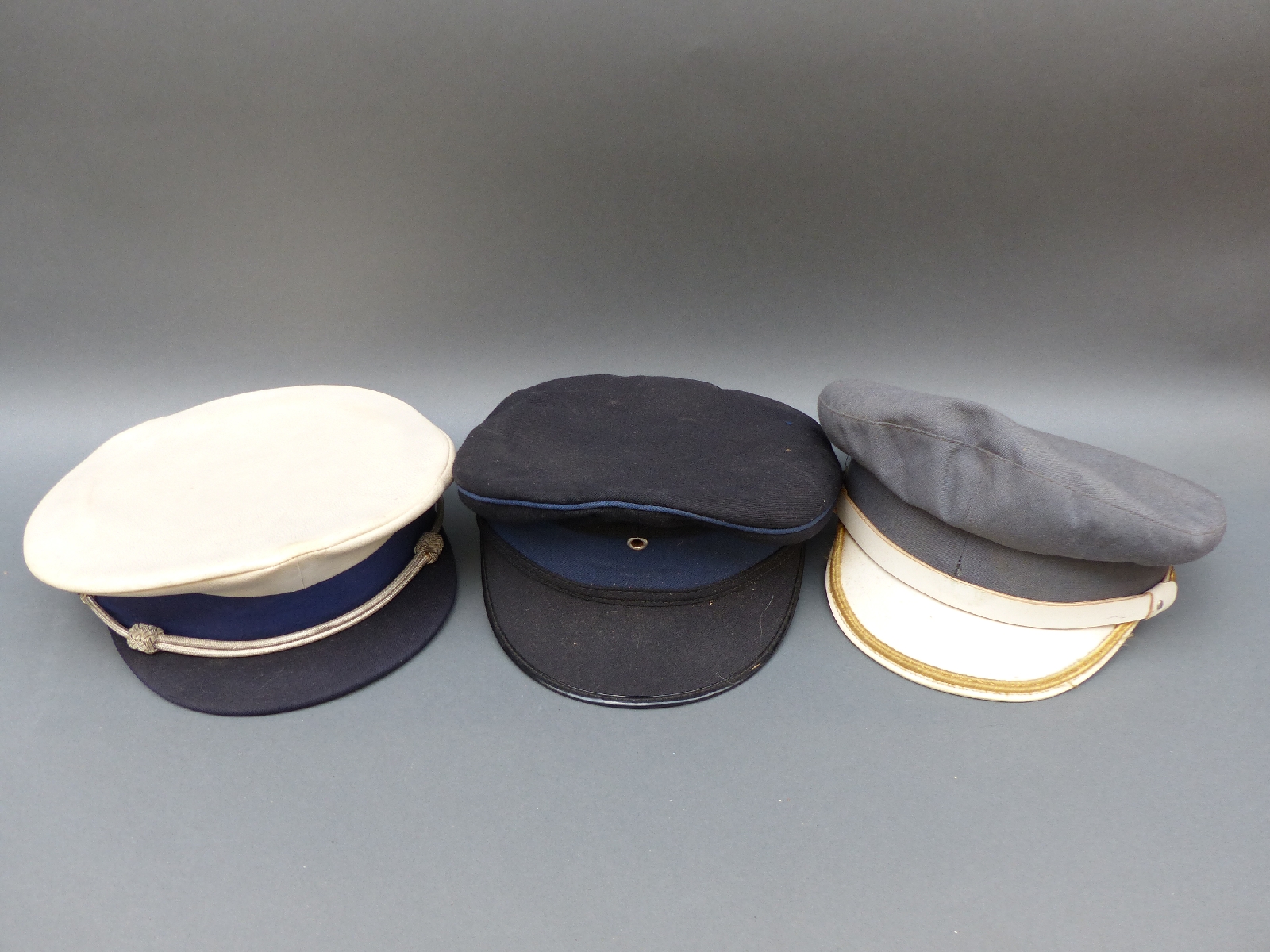 A collection of peaked police caps, some anonymous but most British and ...