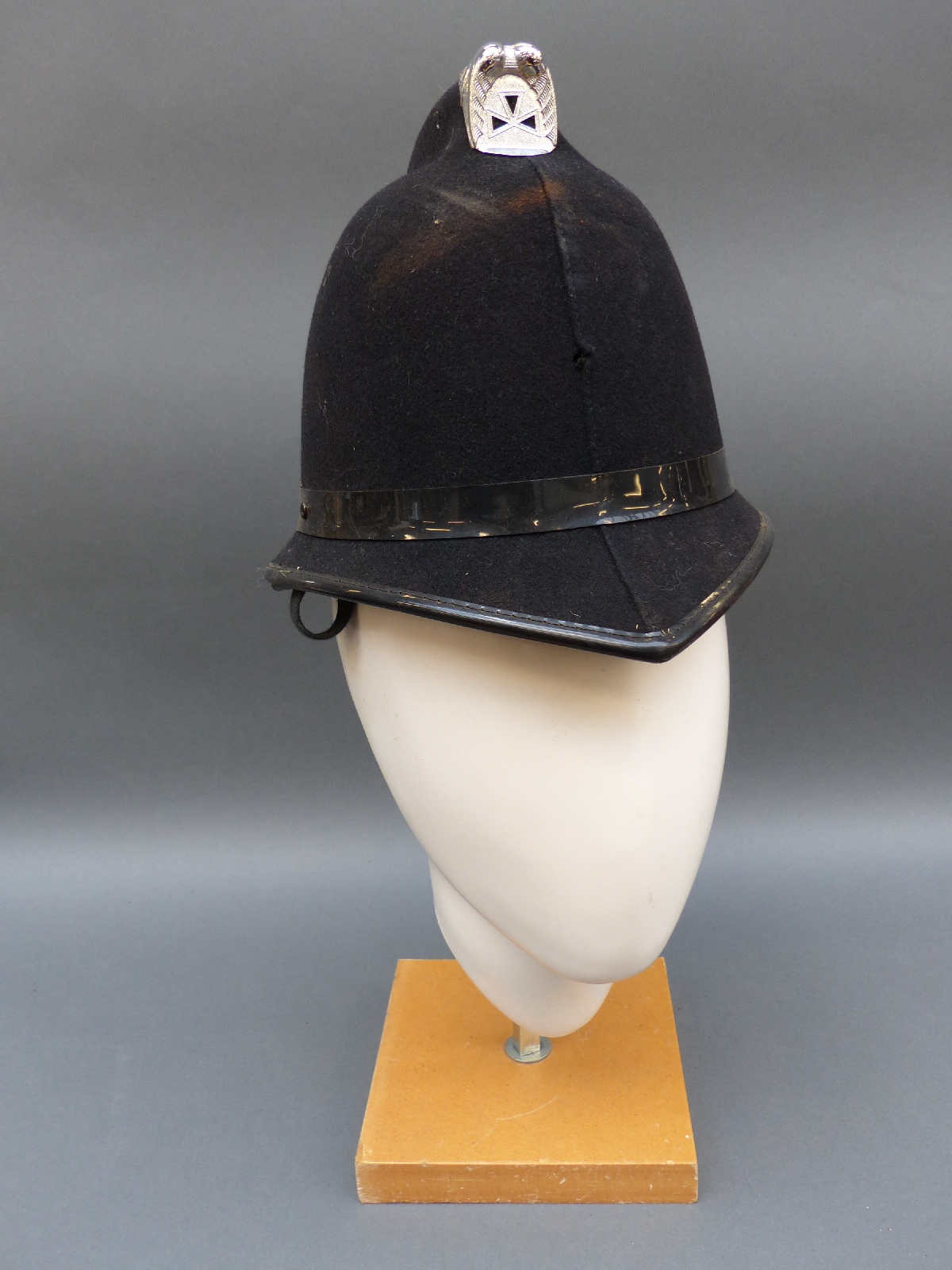 Three vintage police helmets including Devon and Cornwall