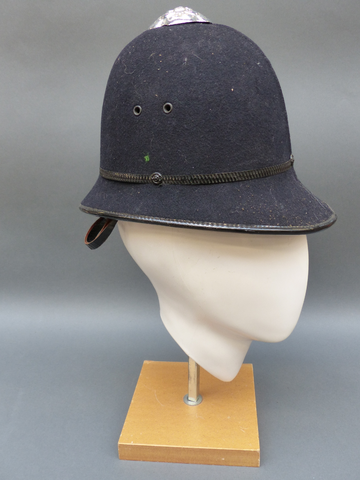 Three vintage police helmets including Devon and Cornwall