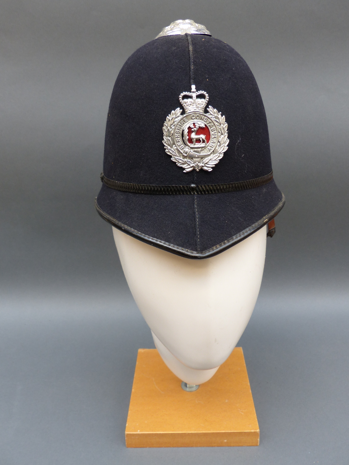 Three vintage police helmets including Thames Valley, Reading and Berkshire