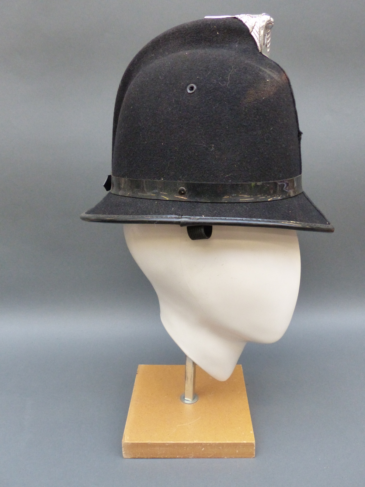 Three vintage police helmets including Devon and Cornwall