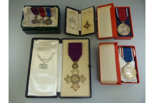 OBE Medals in boxes with OBE certificates