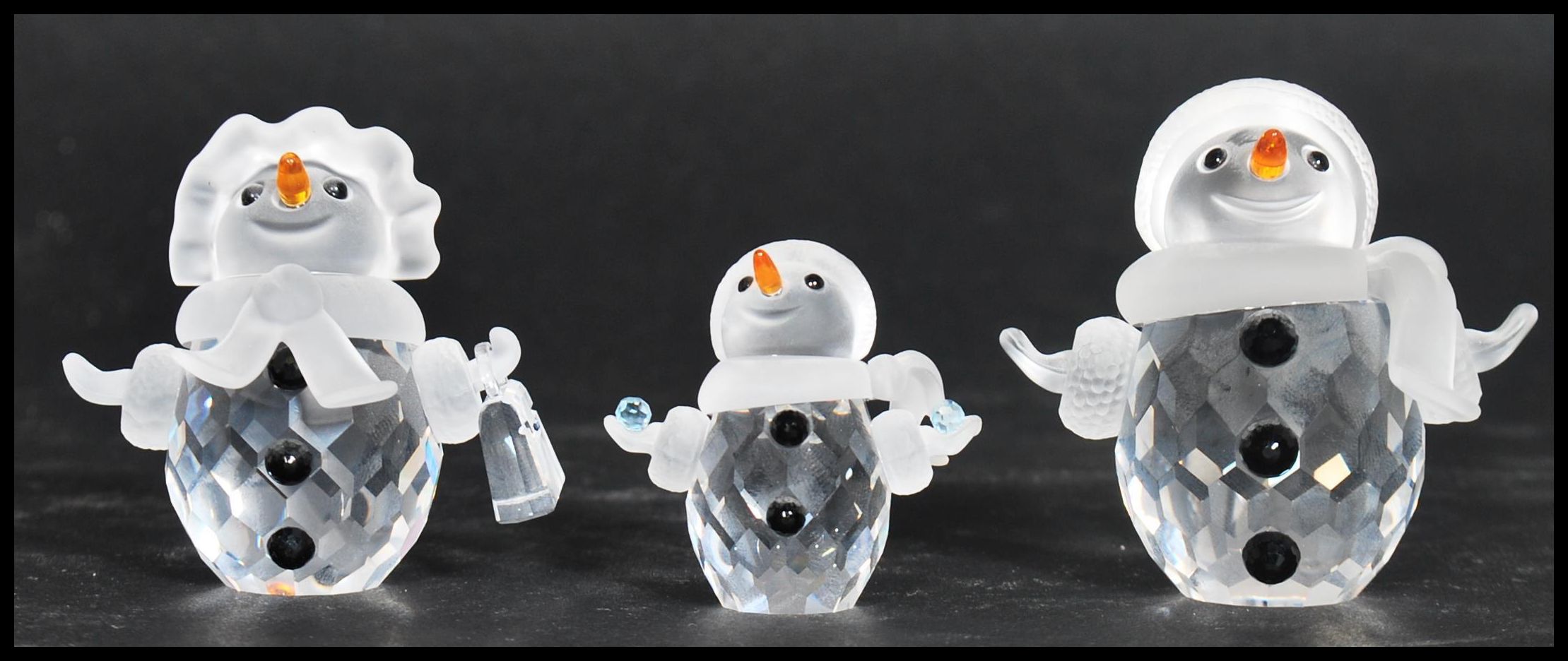 A graduating group of three Swarovski crystal faceted glass snowmen ...