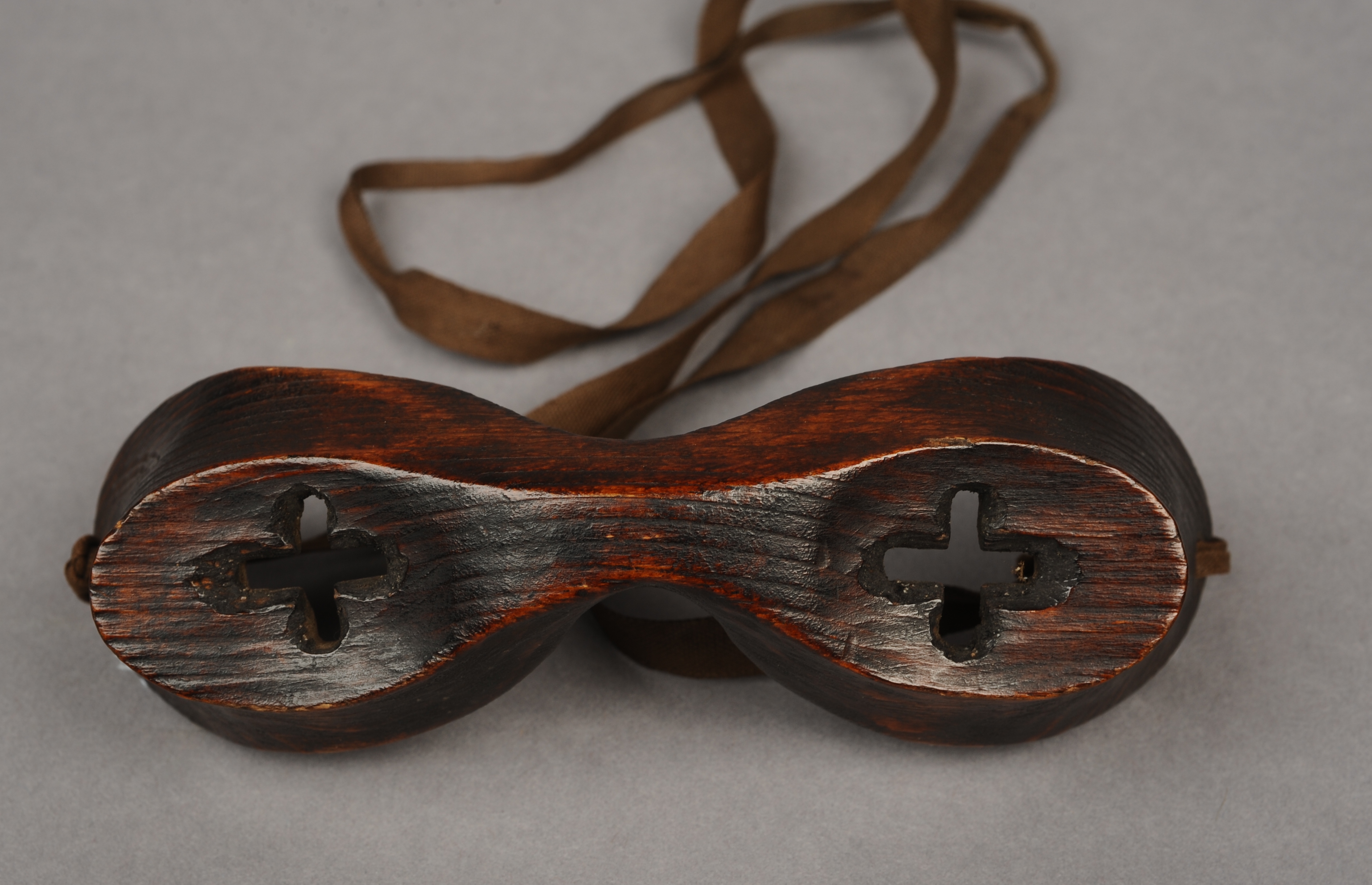 A PAIR OF INUIT-TYPE WOODEN SNOW GOGGLES with cross-shaped eye slits ...
