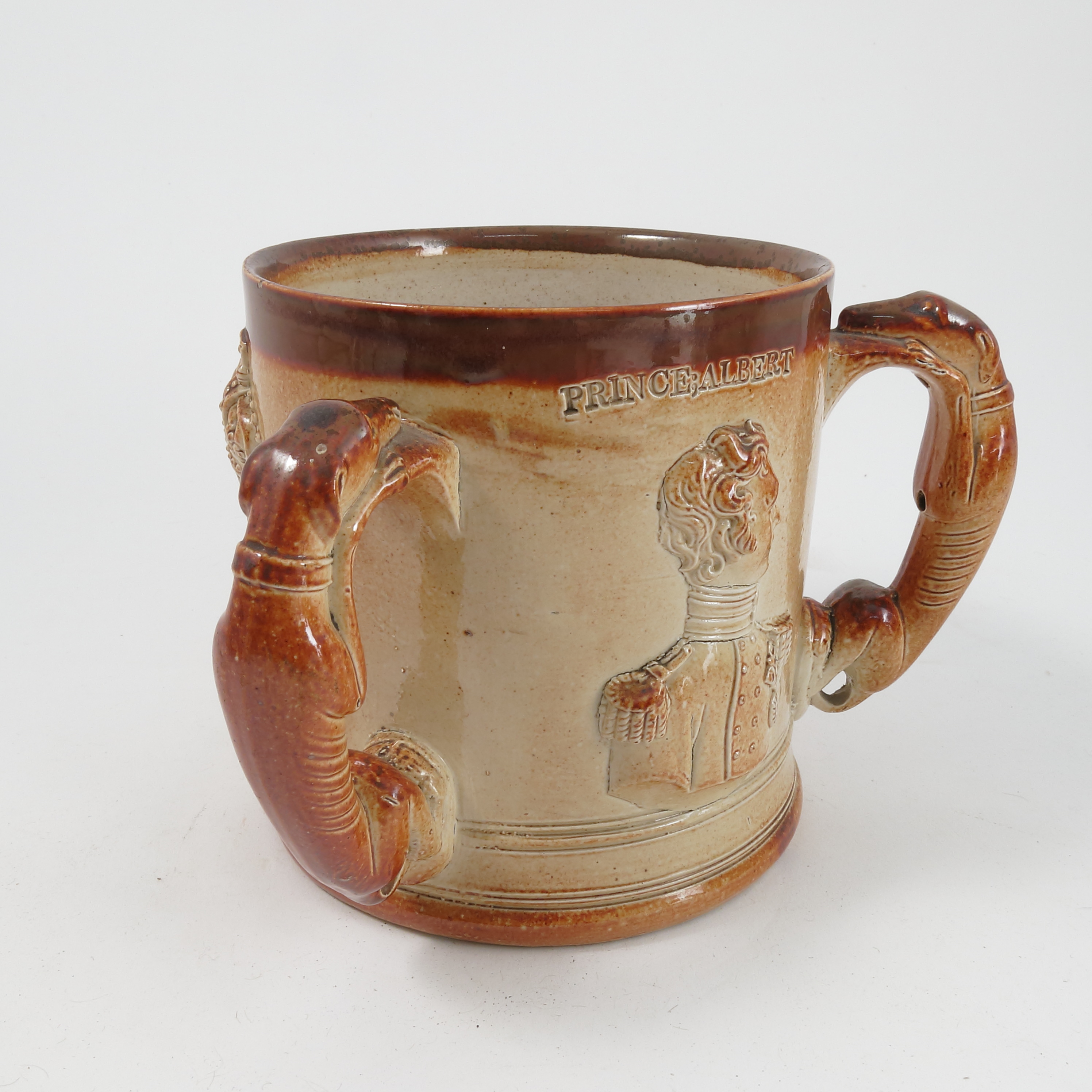 A 19th century stoneware commemorative three handled mug, decorated ...