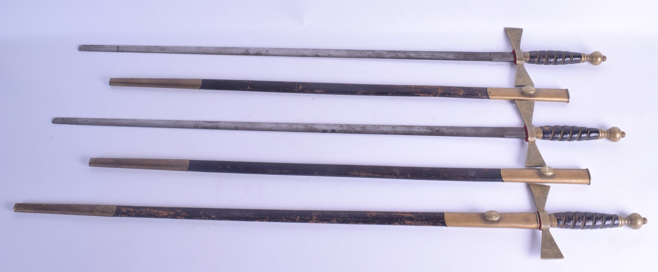 A SET OF THREE ANTIQUE BRASS HANDLED SWORDS with cross type terminal ...