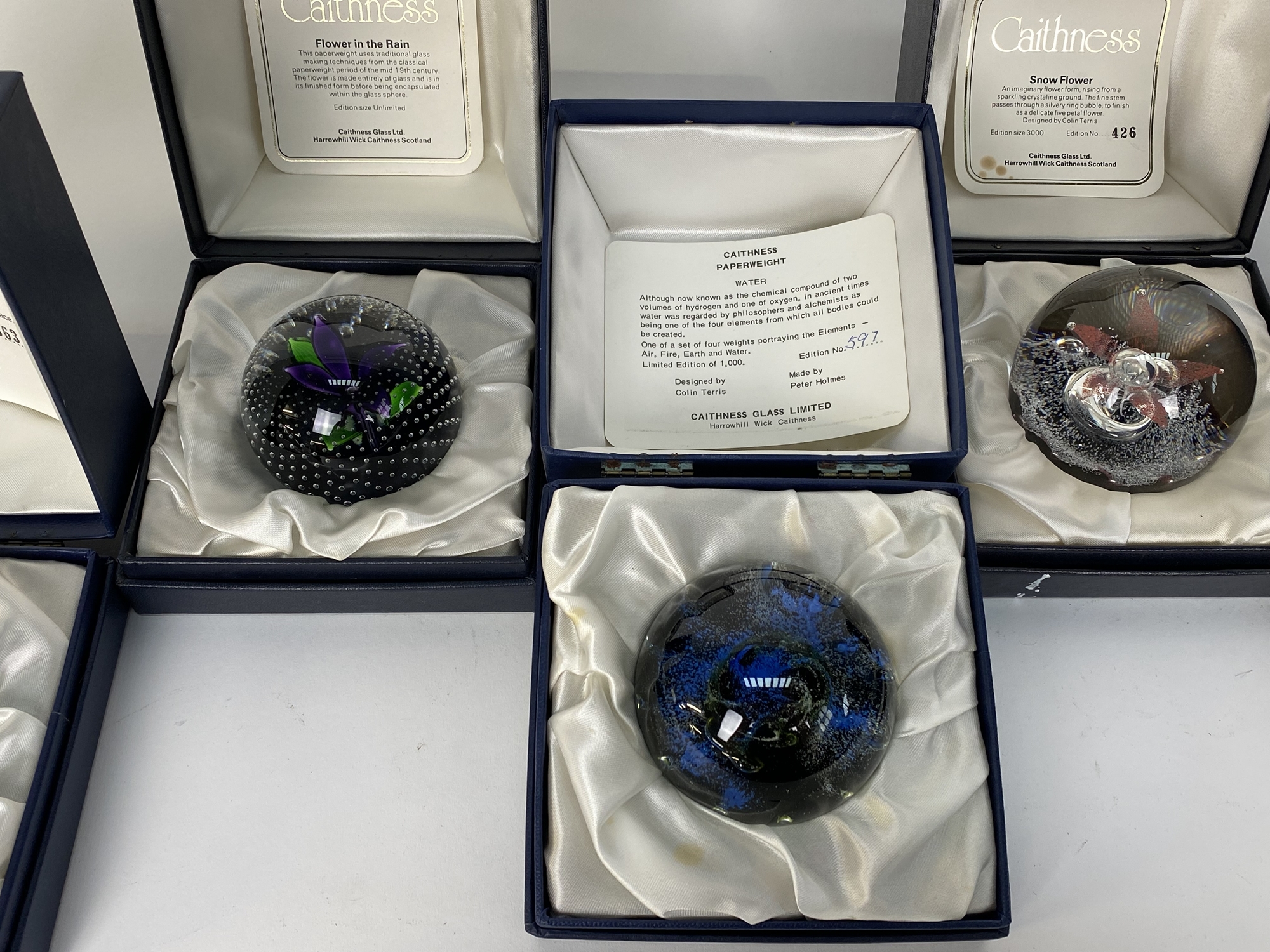 Five Caithness paperweights, with certificates, based on designs by ...
