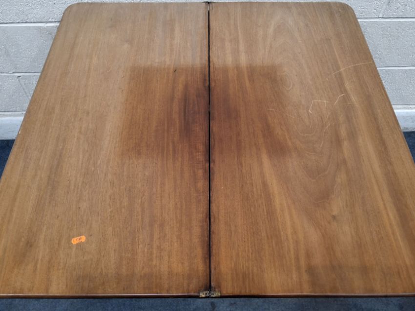 A REGENCY MAHOGANY TEA TABLE, with a rotating fold-over top, raised on ...