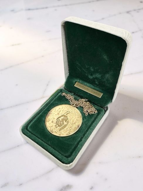A John Pinches silver-gilt disc pendant on chain,