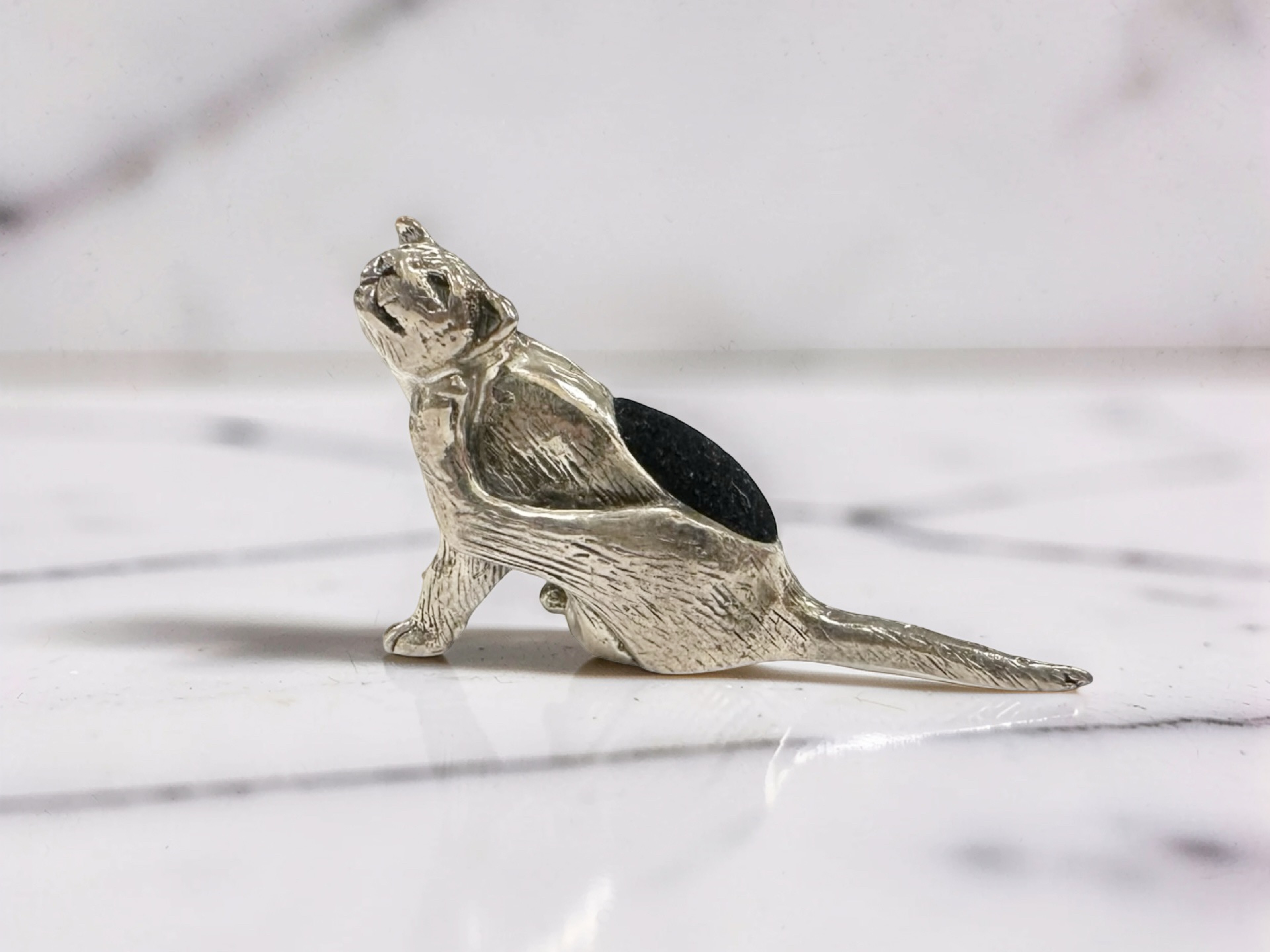 A sterling silver novelty pin cushion in the form of a cat, stamped 925.