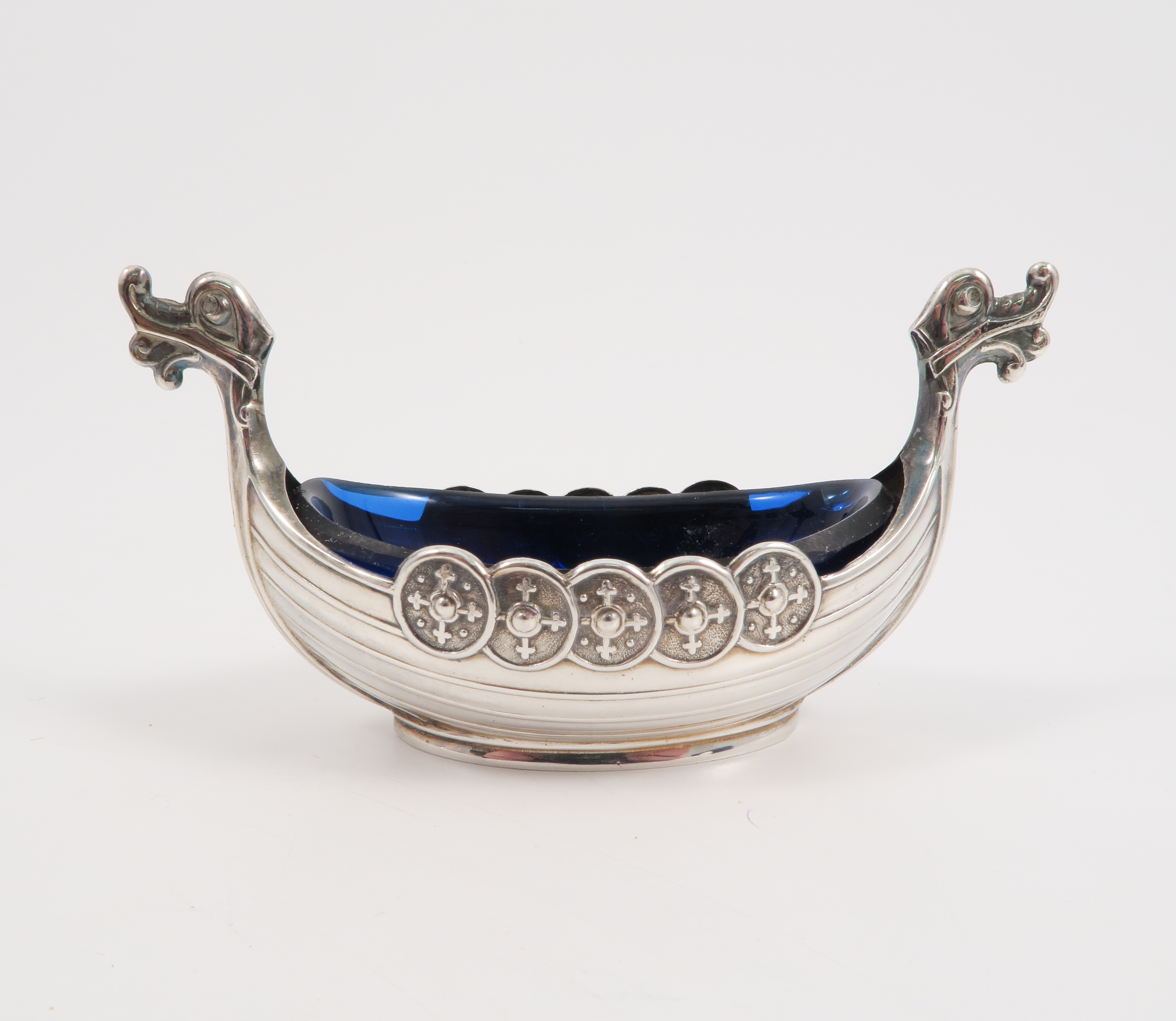 A Norwegian silver salt, formed as a Viking boat, with blue glass liner ...