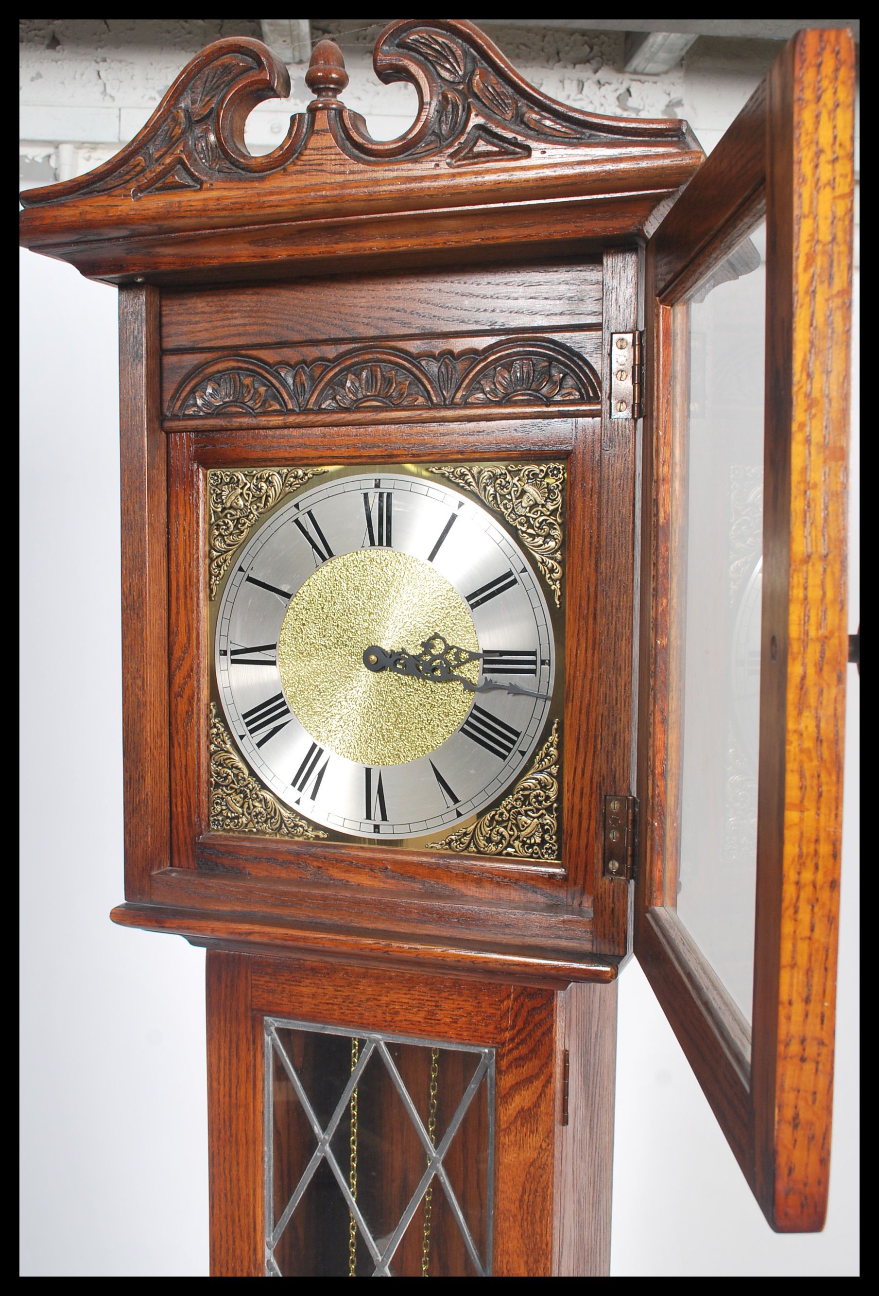 A 20th century antique style oak longcase grandfather clock with brass ...
