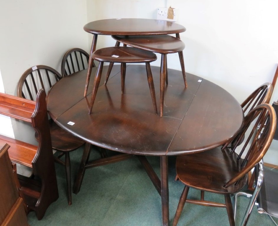 An Ercol dark wood dropleaf dining table with four Ercol hoop back ...