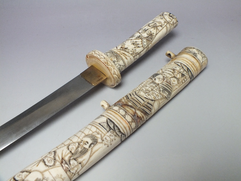 A JAPANESE SHORT SWORD WITH CARVED BONE HANDLE AND SCABBARD, the brass ...