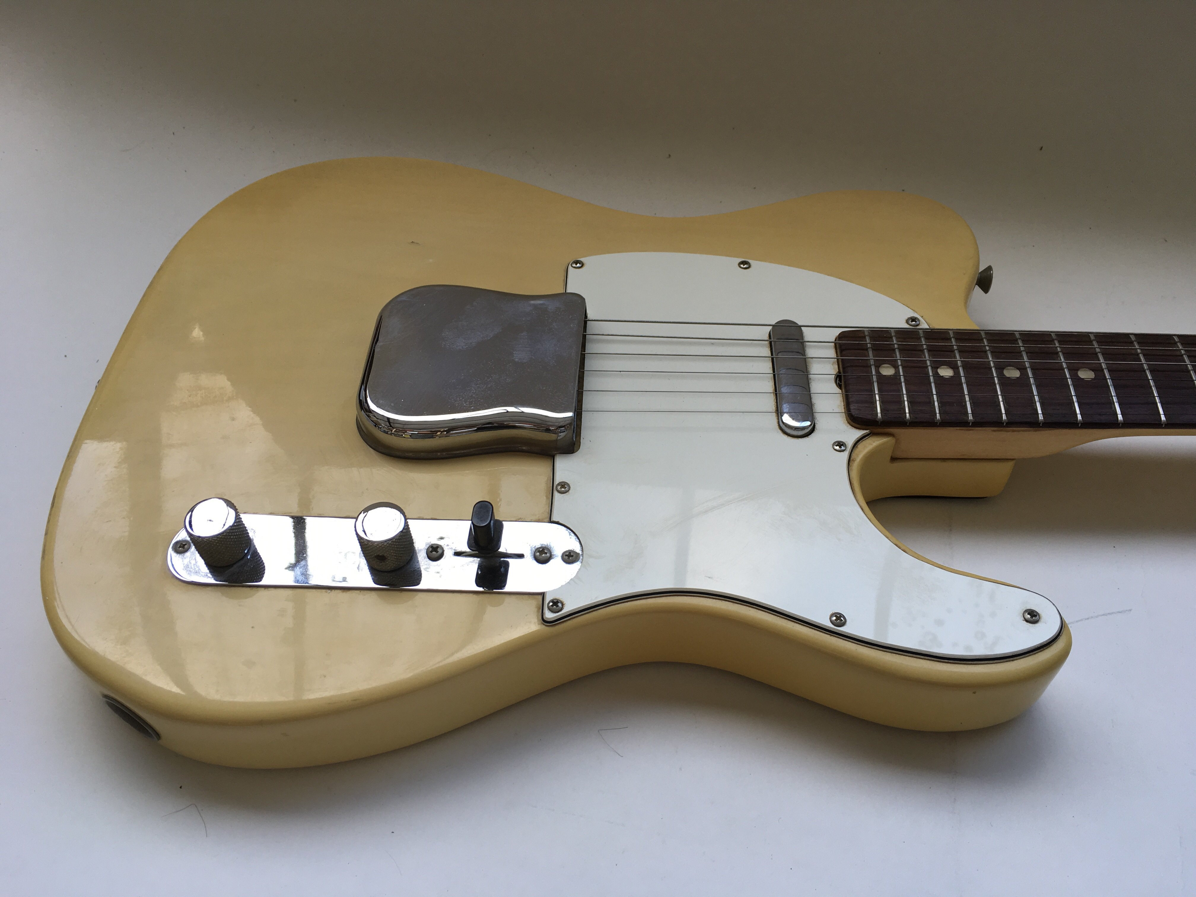 A Fender Telecaster guitar in butterscotch finish with a white scratch ...