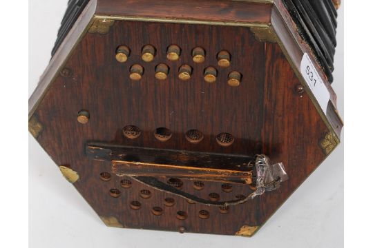 A vintage wooden squeeze box accordion instrument with central bellows ...
