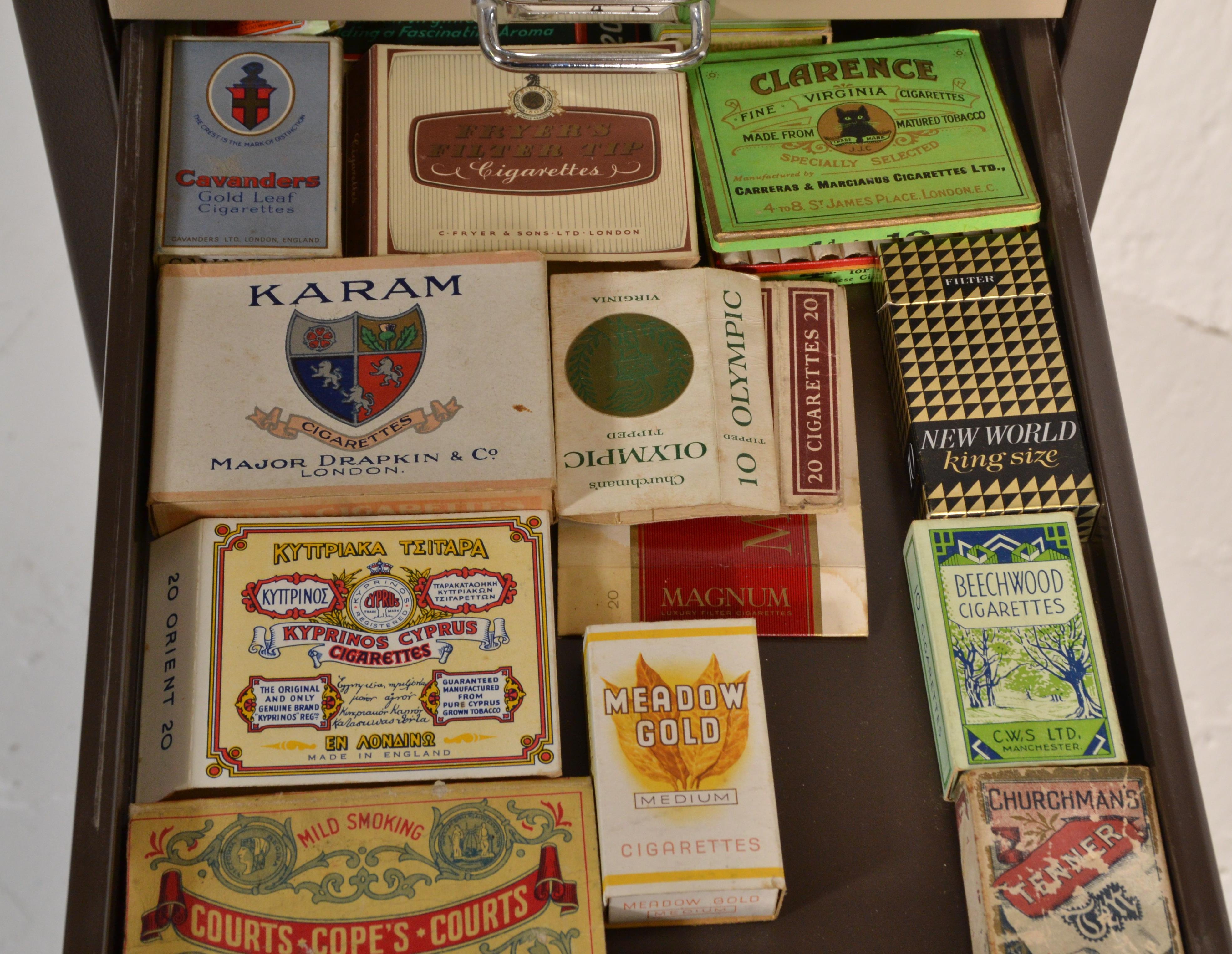 A collection of vintage Cigarette packets stored within a metal filing ...