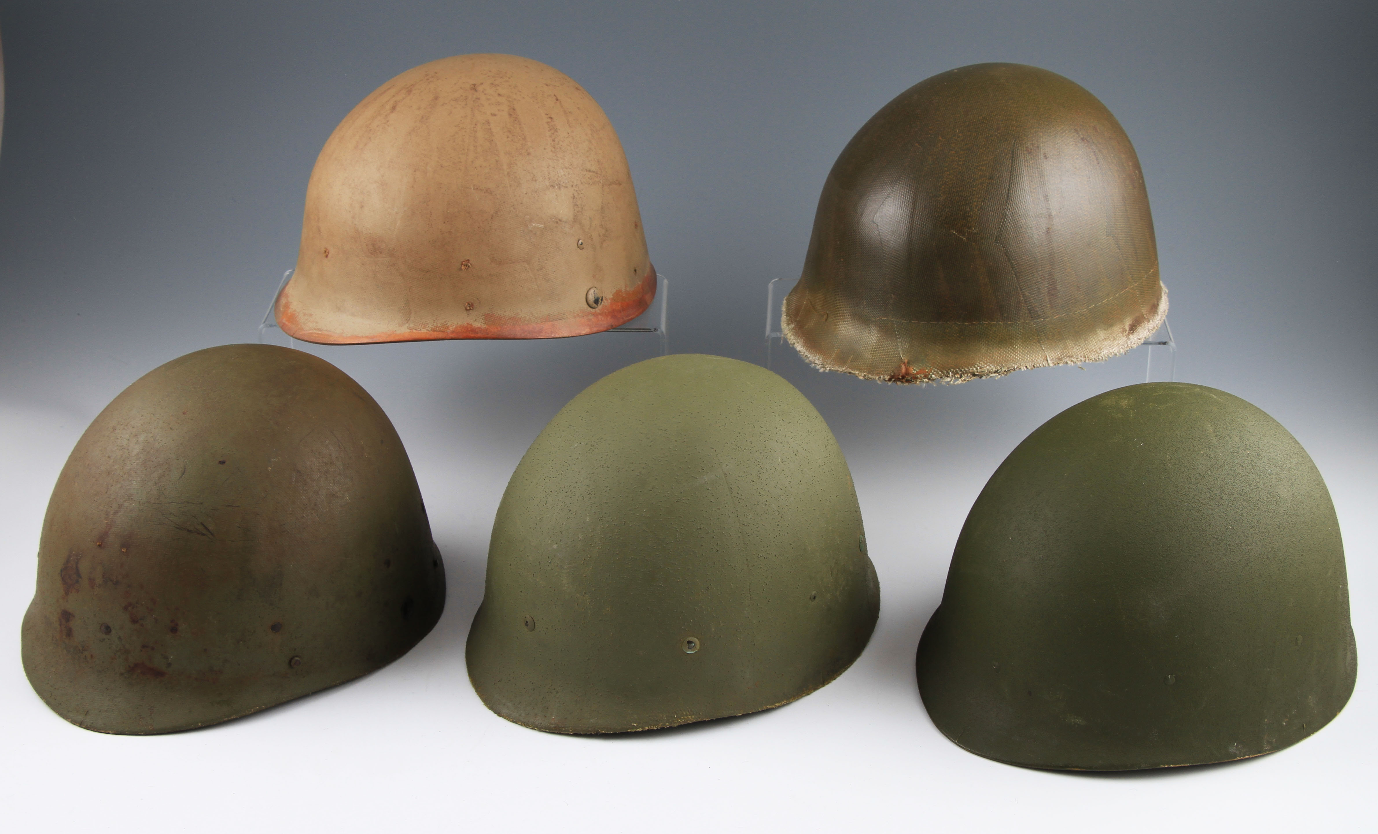 A lot to include two US M1 helmets, one having green the cover the ...