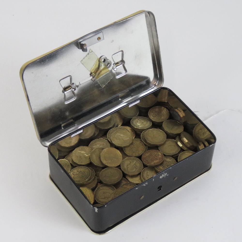 A contemporary tin moneybox with key containing a quantity of ...