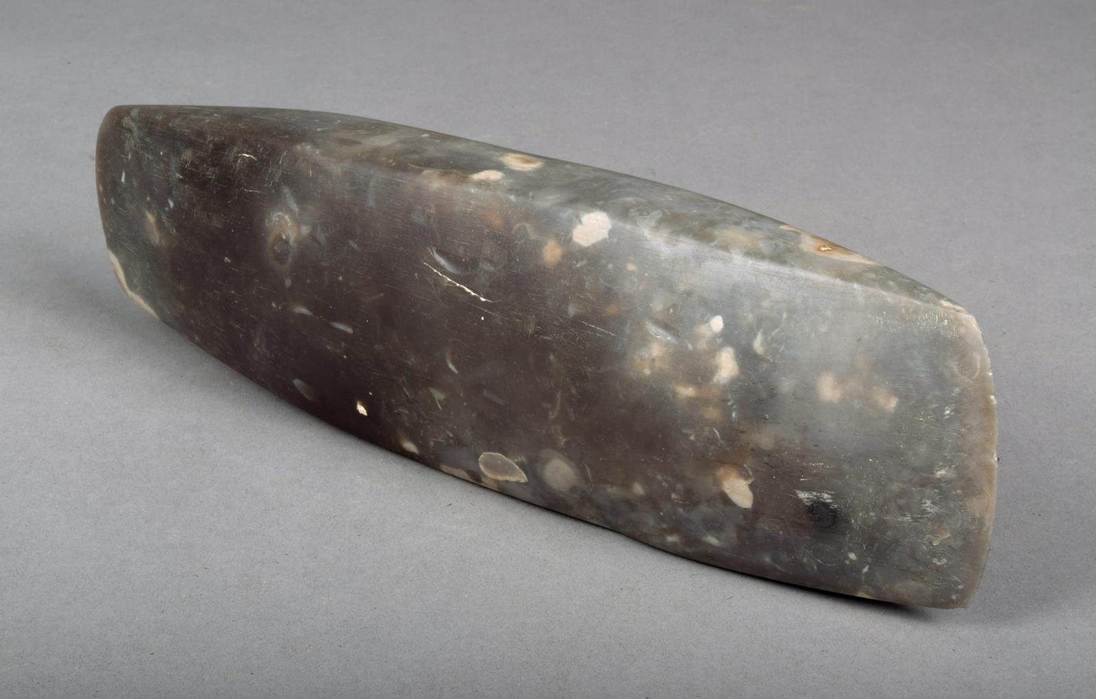 A Neolithic adze blade of rectangular form with pointed ends 28.5cm long.